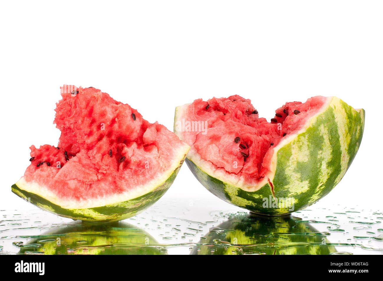 Watermelon broken pieces on white mirror background in water drops ...