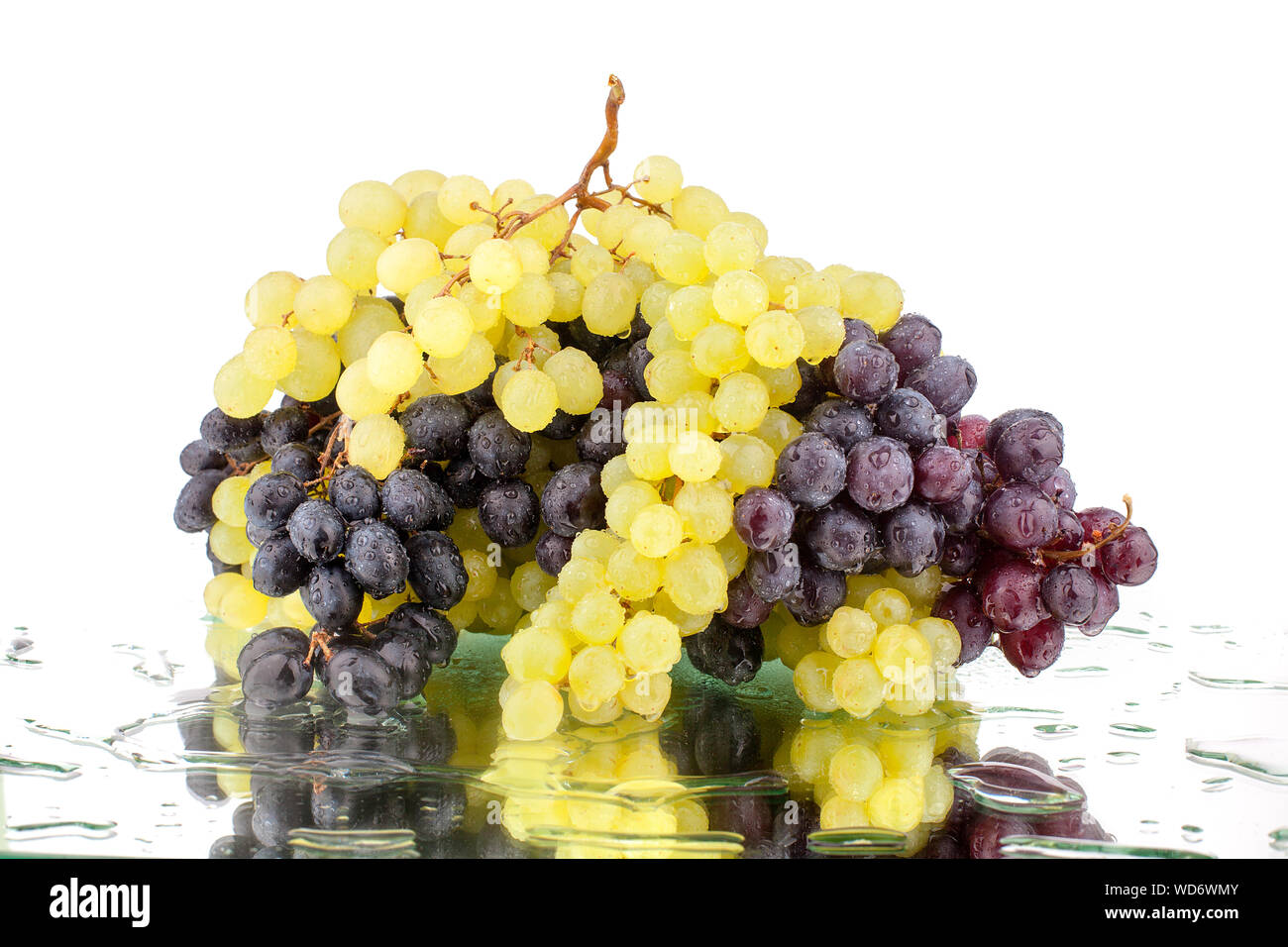 Bunches of black, red and white grapes on a white mirror background in ...