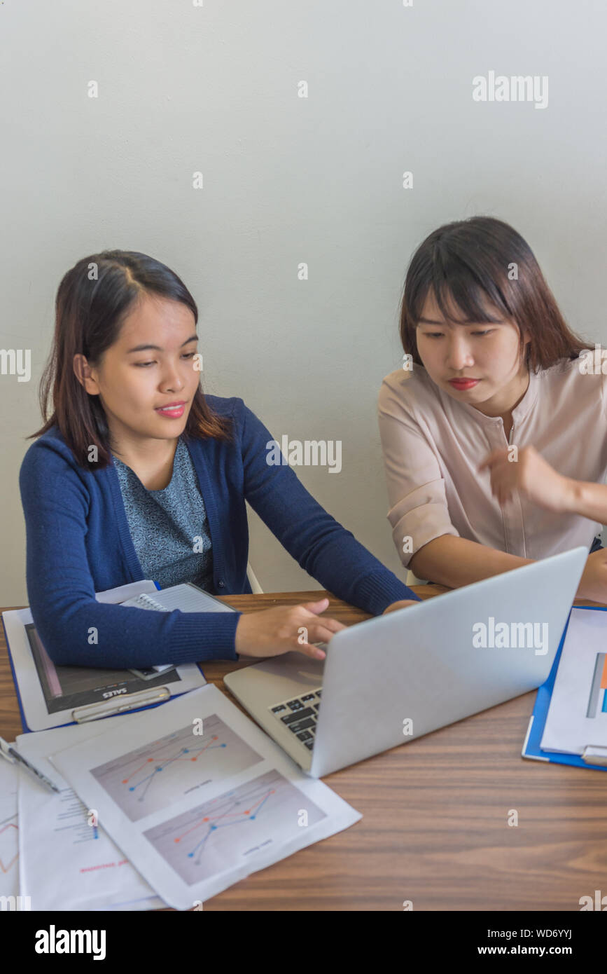 Vertical photo of two ladies working on laptop and documents Stock ...
