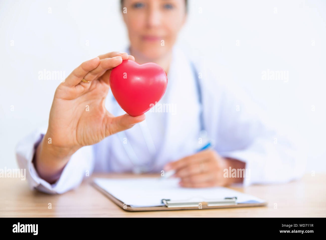 Medical Cardiologist Doctor is Holding Red Heart to Patient, Female ...