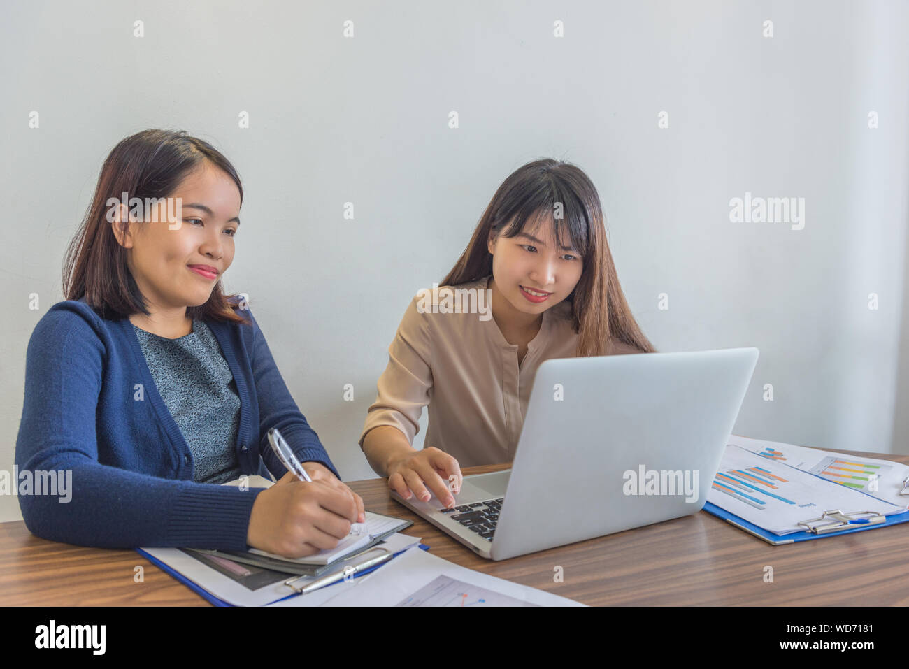 Asian female financial advisors using laptop and having business ...