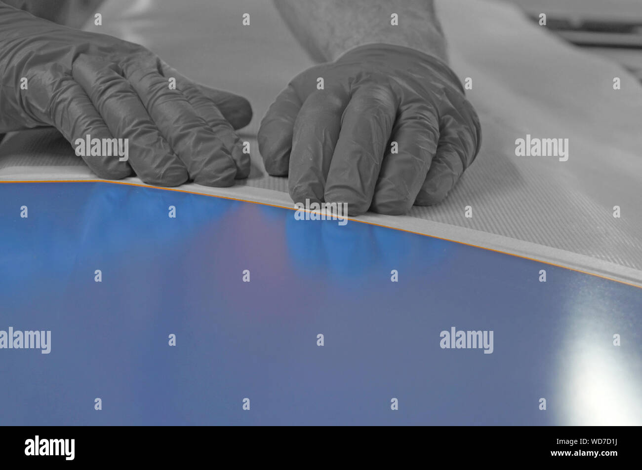 Man lining out metal panel with tape and covering with paper and ...