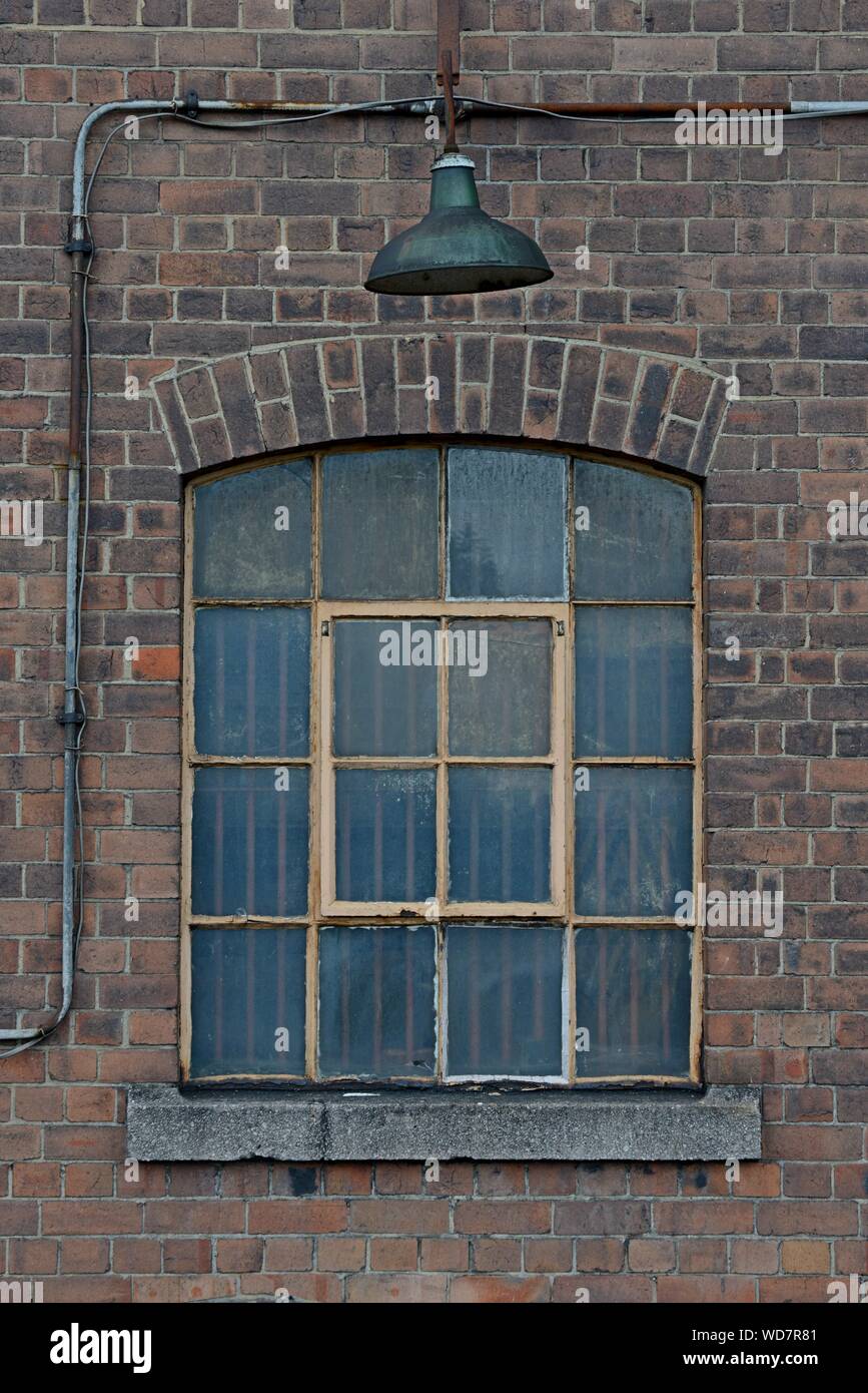 A vintage industrial light fitting over a broken window at Didcot ...