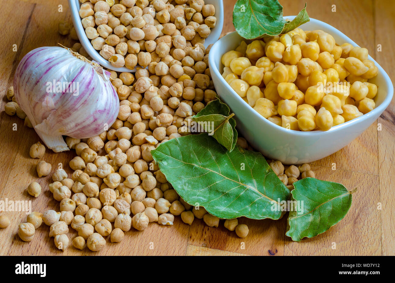 Dried chickpeas and boiled chickpeas arranged on a kitchen counter top ...