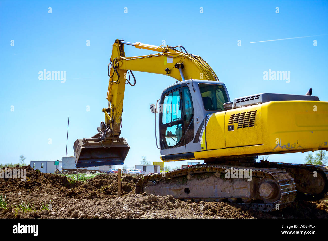Big excavator is excavating soil at construction site, project in ...