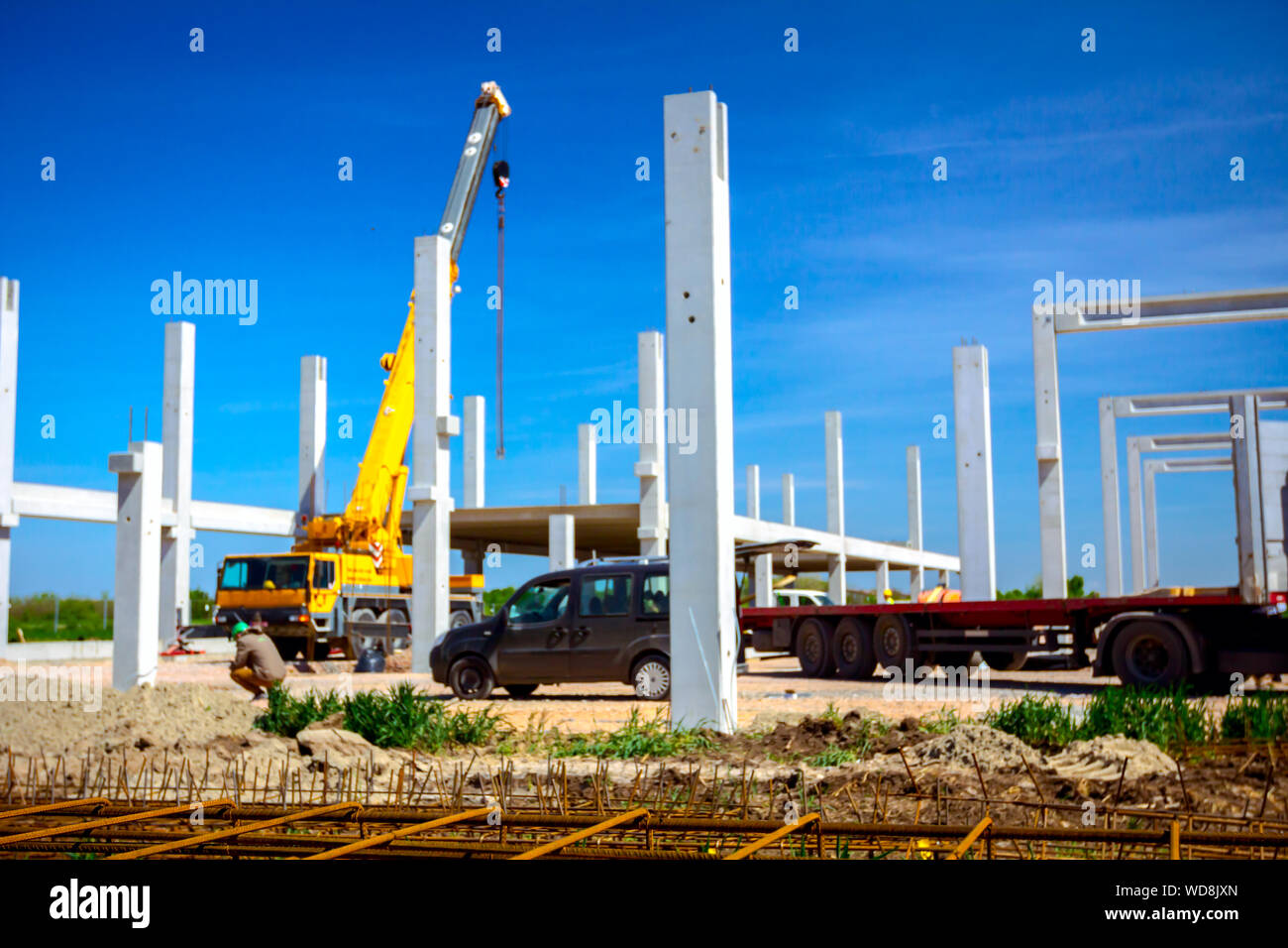 Assembly a huge concrete skeleton of industrial building with machinery ...