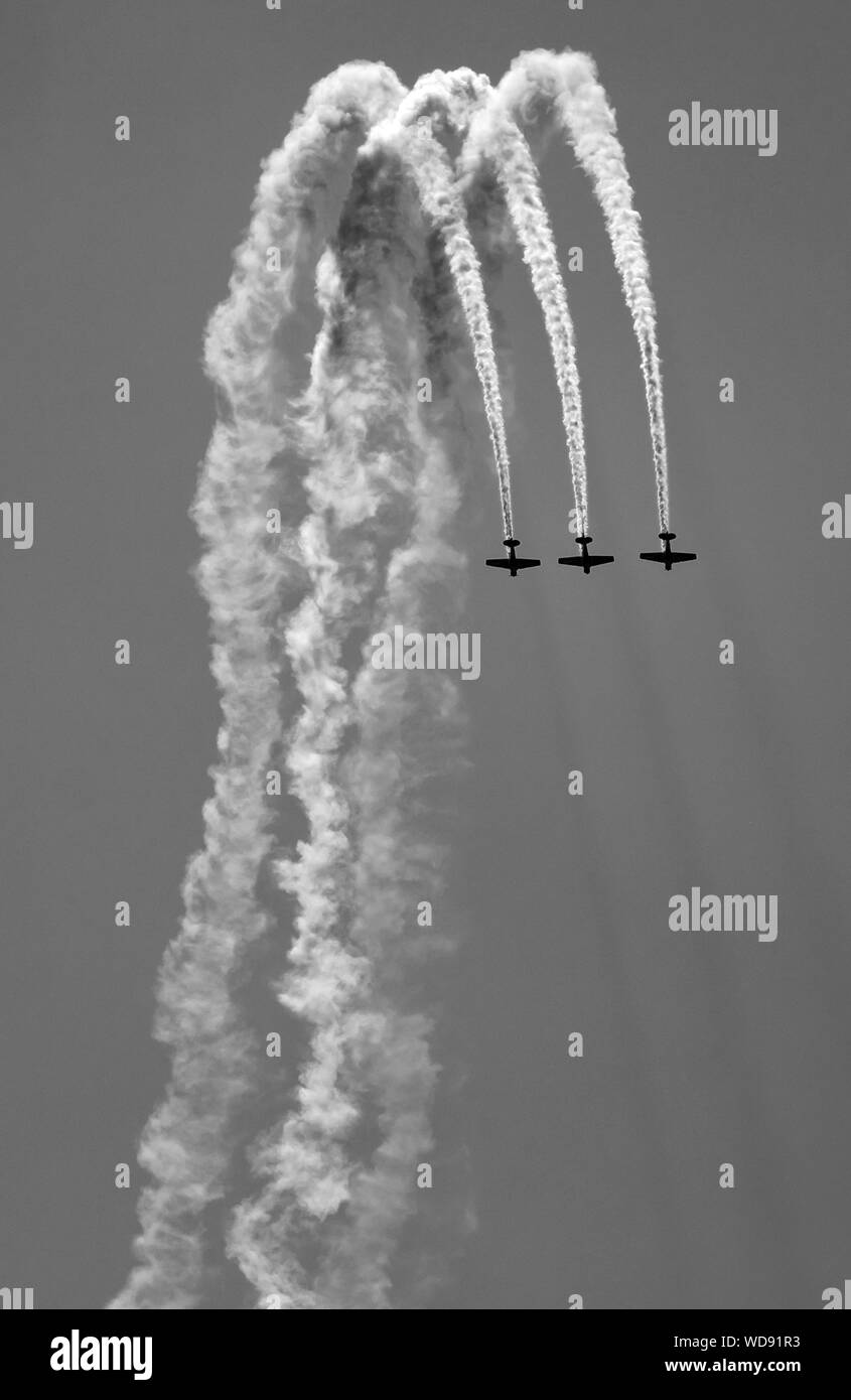 Three plane formation at air show with a smoke trail Stock Photo - Alamy