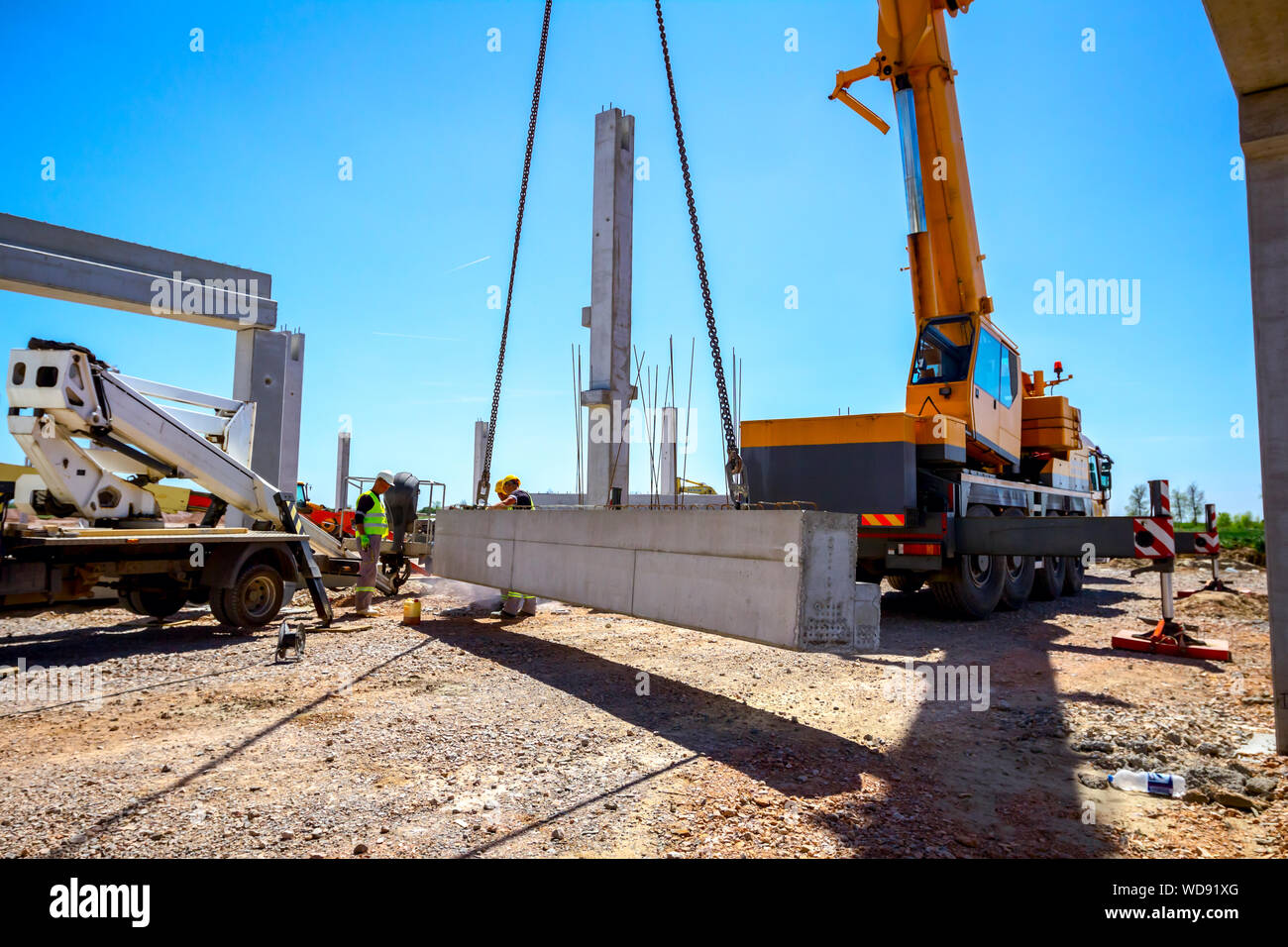 Worker is using abrasive grinding machine to set up concrete joist to ...