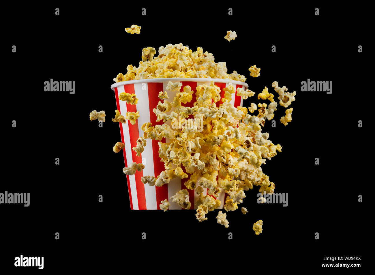 Flying popcorn from striped bucket isolated on black background Stock ...