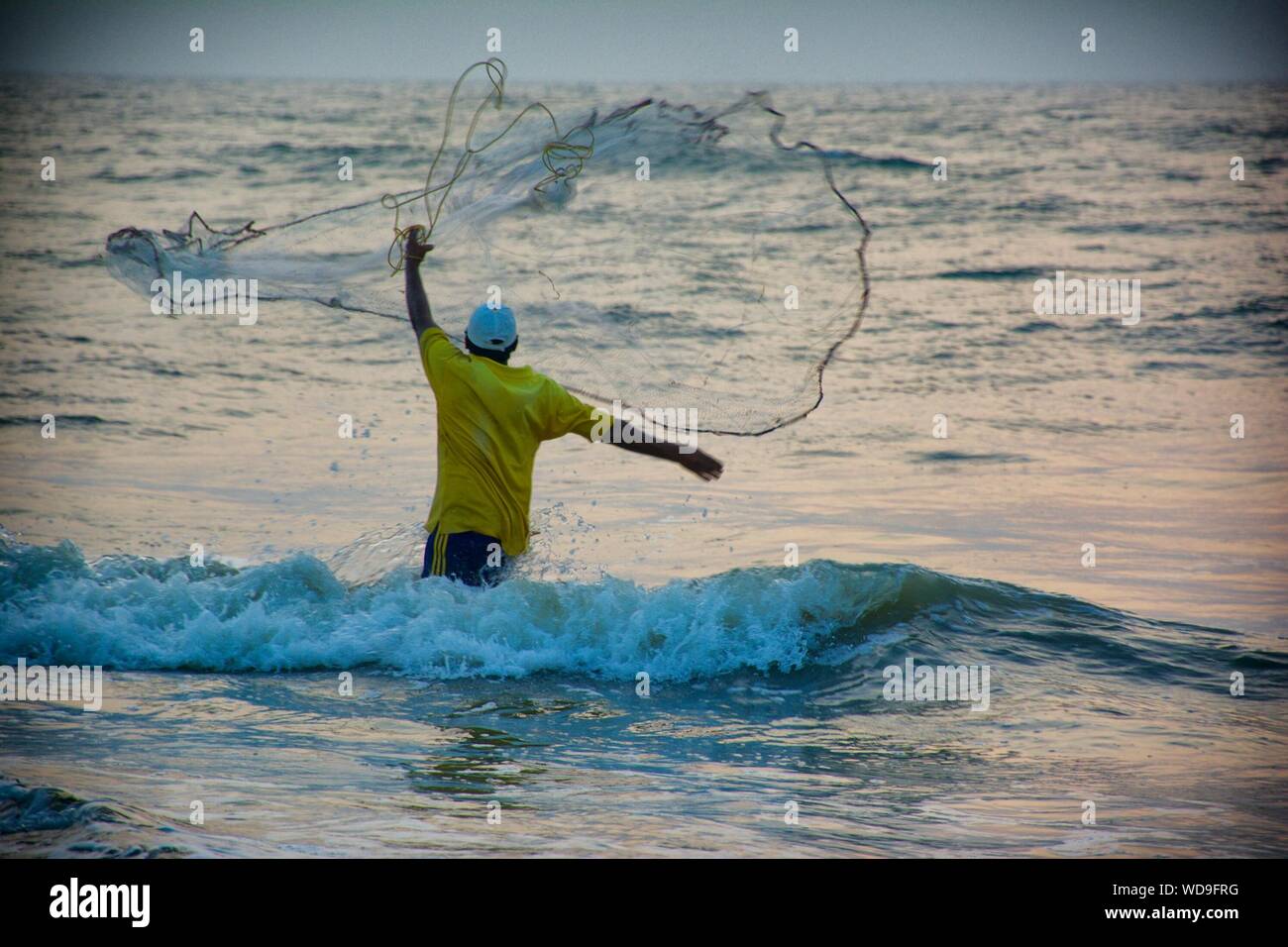 Fisherman throwing net in sea day hi-res stock photography and images ...