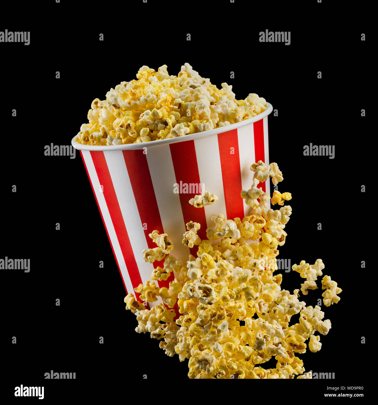 Flying popcorn from striped bucket isolated on black background Stock ...
