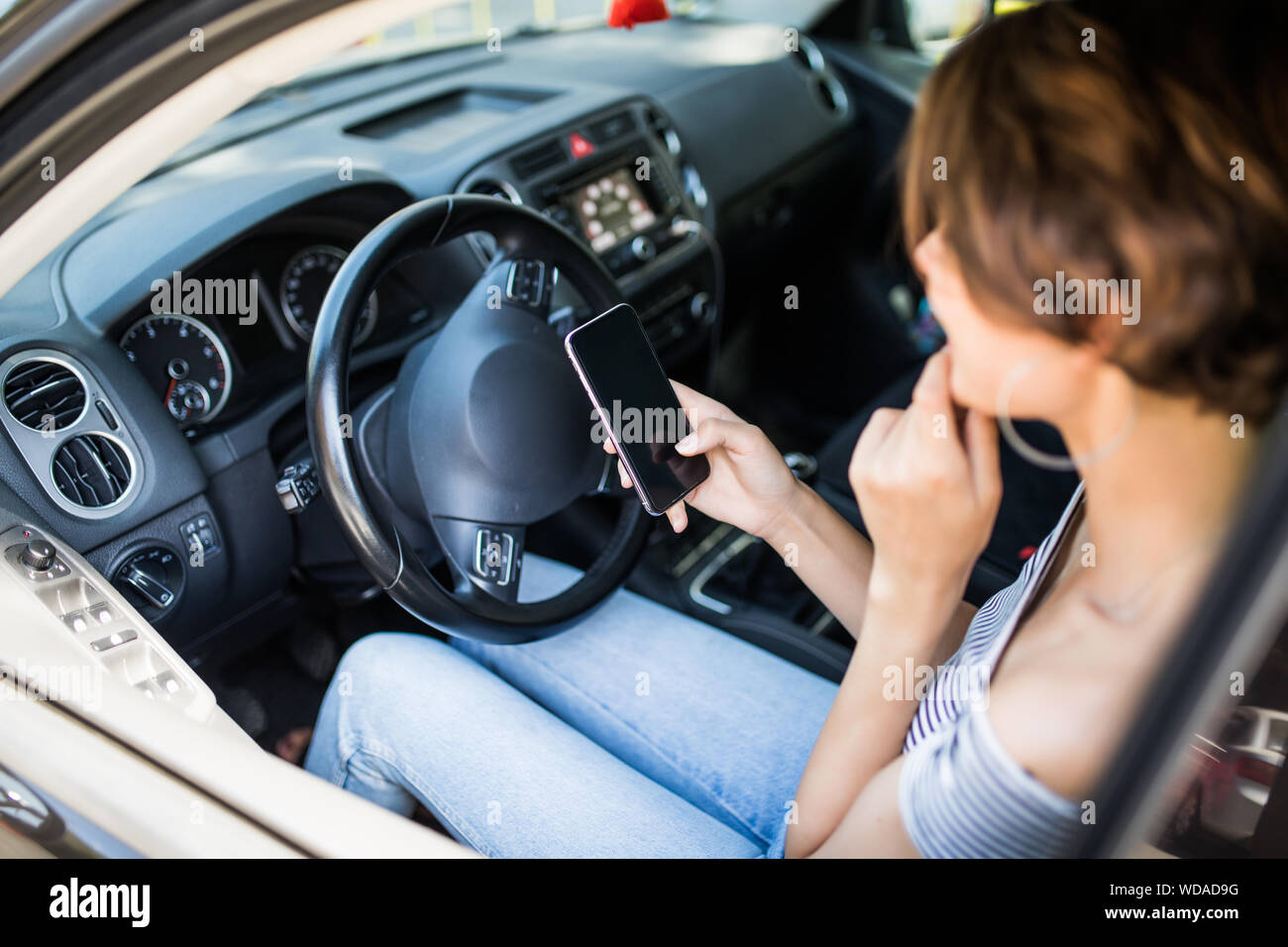 Rear view of attractive young woman in casual wear looking over her ...