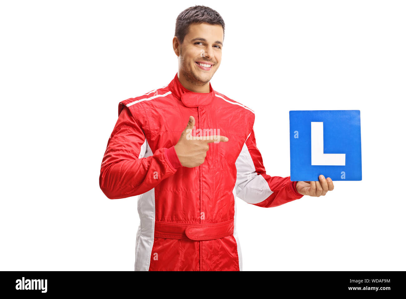 Smiling young racer holding a learner plate and pointing isolated on ...