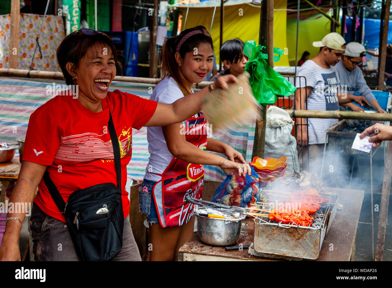 Filipino Women Cooking Meat On A Grill During The Dinagyang Festival ...
