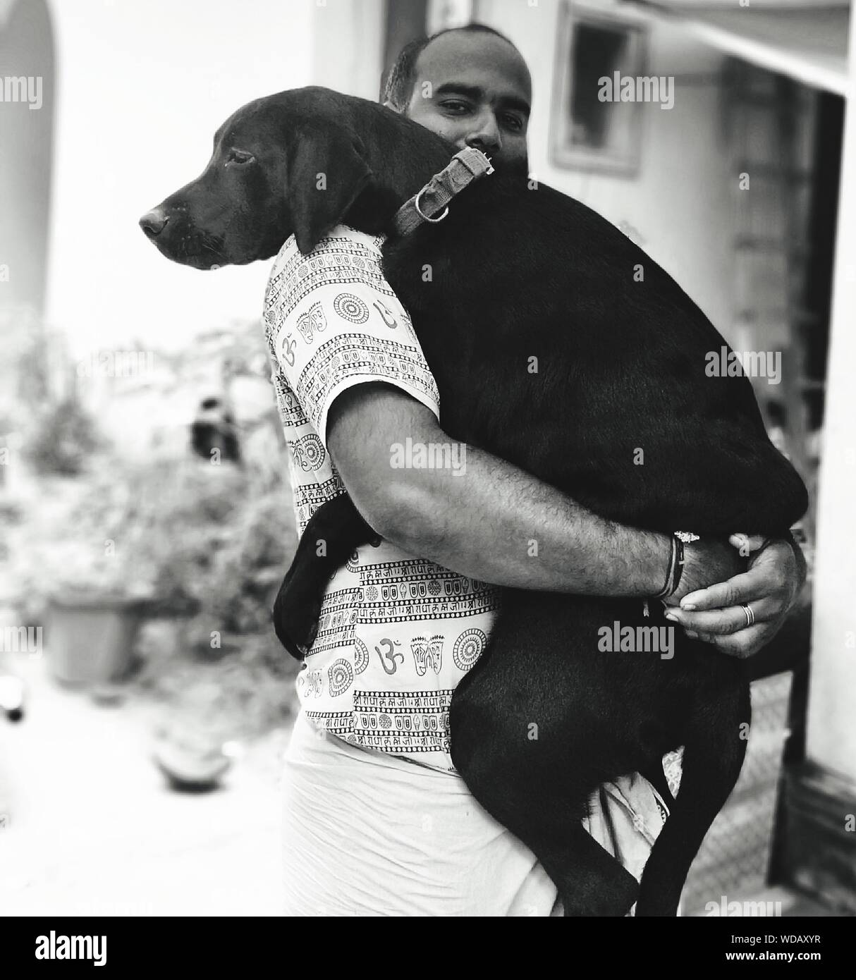 Portrait young man carrying dog hi-res stock photography and images - Alamy