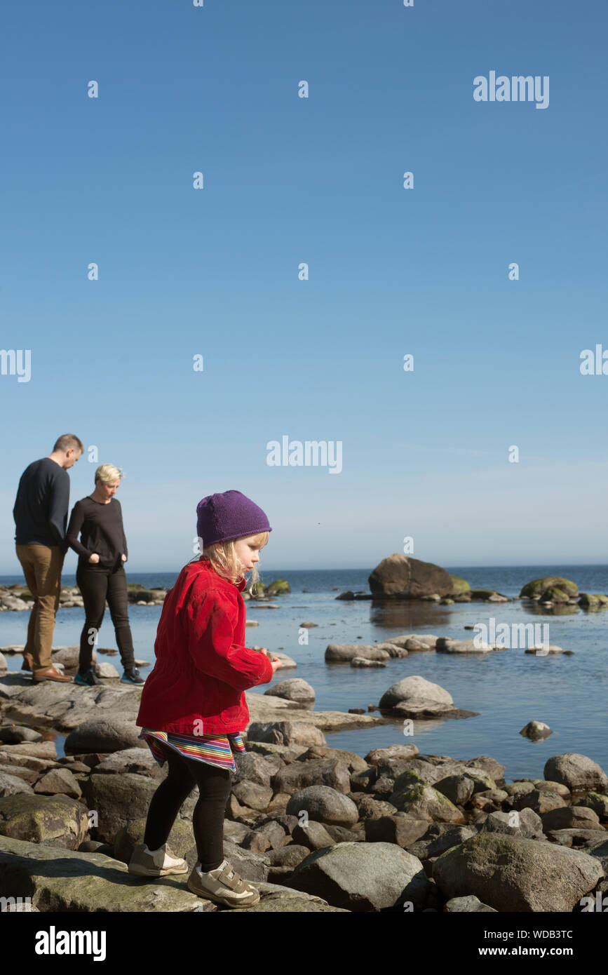 Parents with daughter on rocks Stock Photo - Alamy