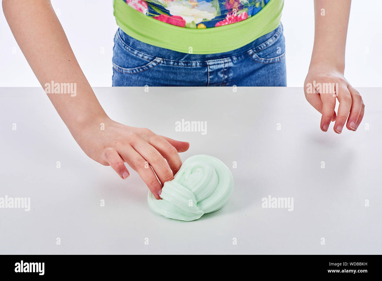 Child hand playing with homemade green slime. Isolated on white ...