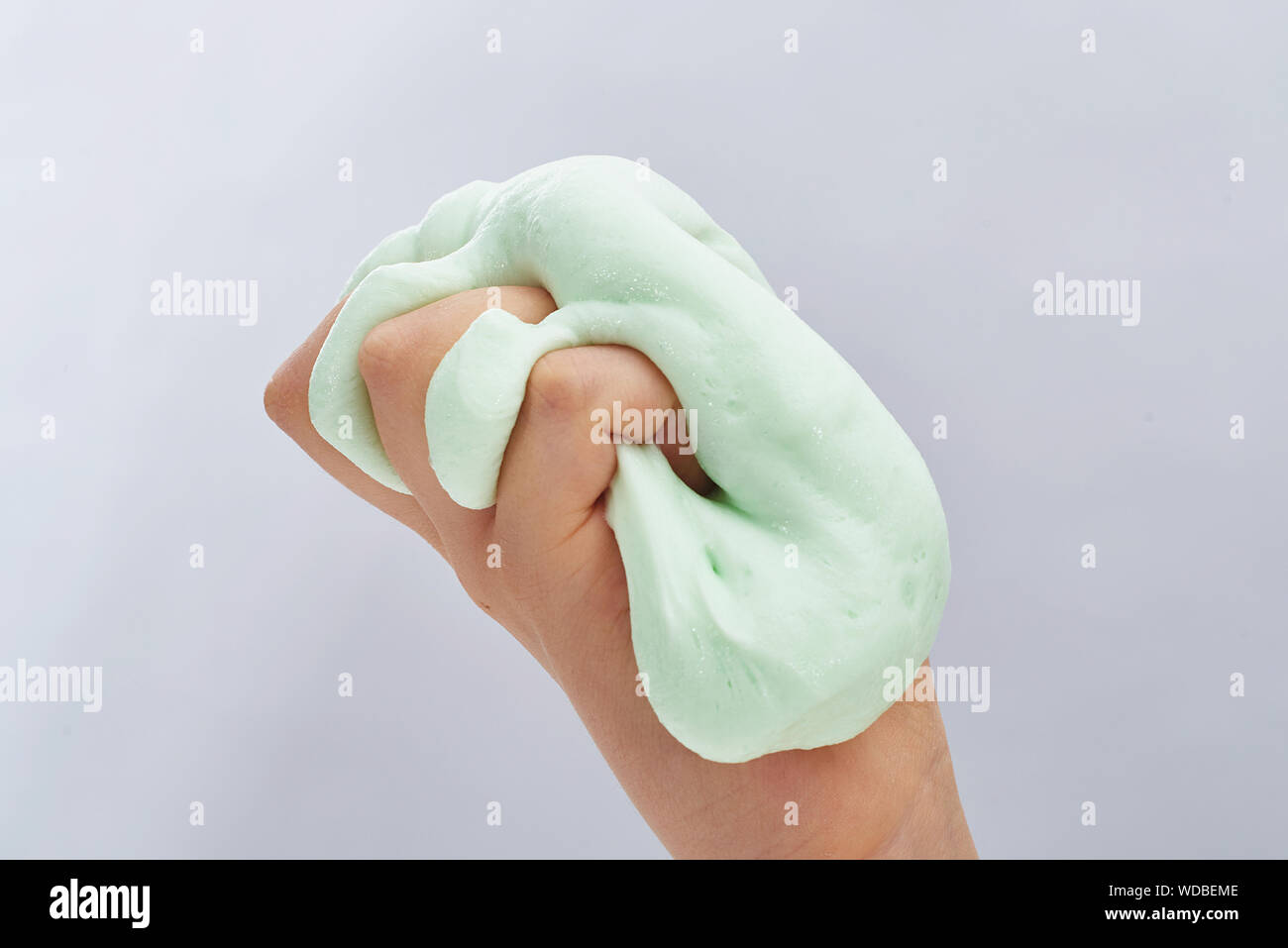 Hand squeezing green slime. Isolated on white background Stock Photo ...