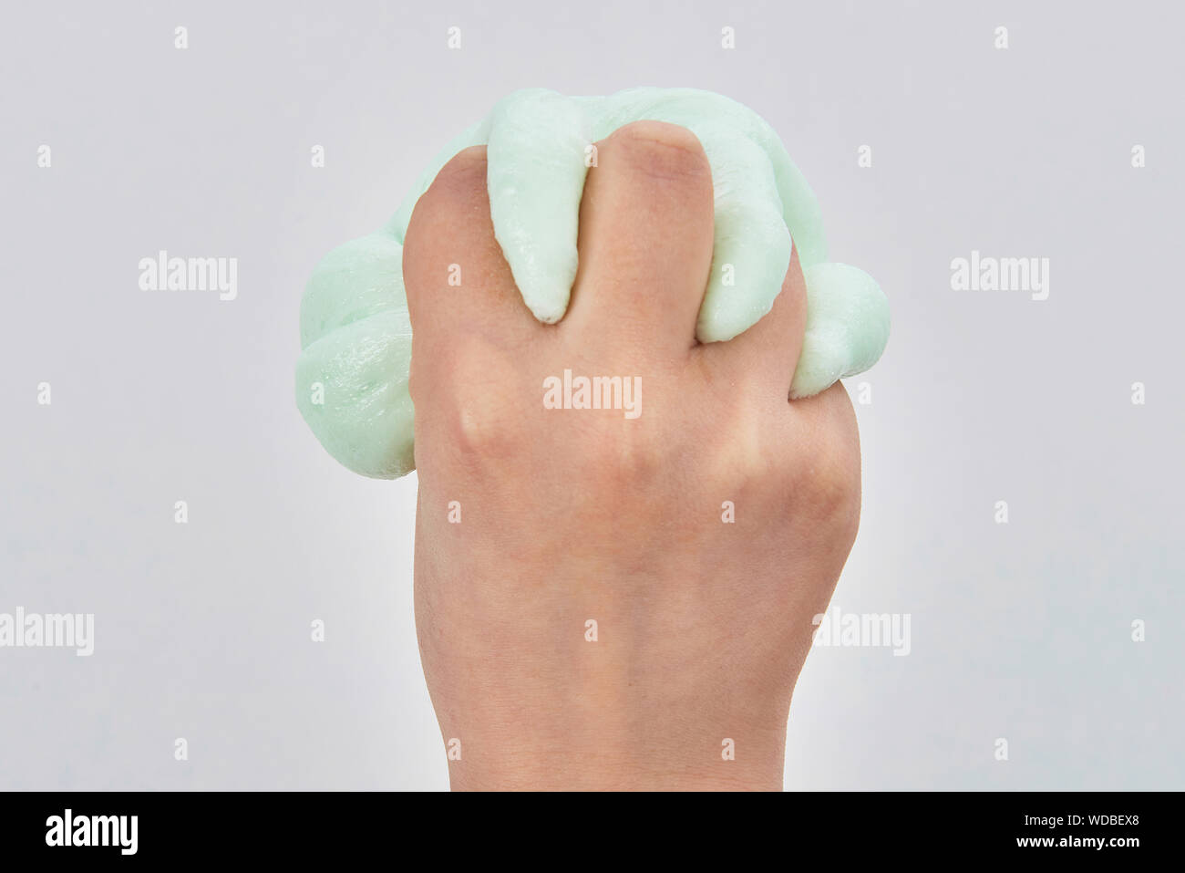 Hand squeezing green slime. Isolated on white background Stock Photo ...