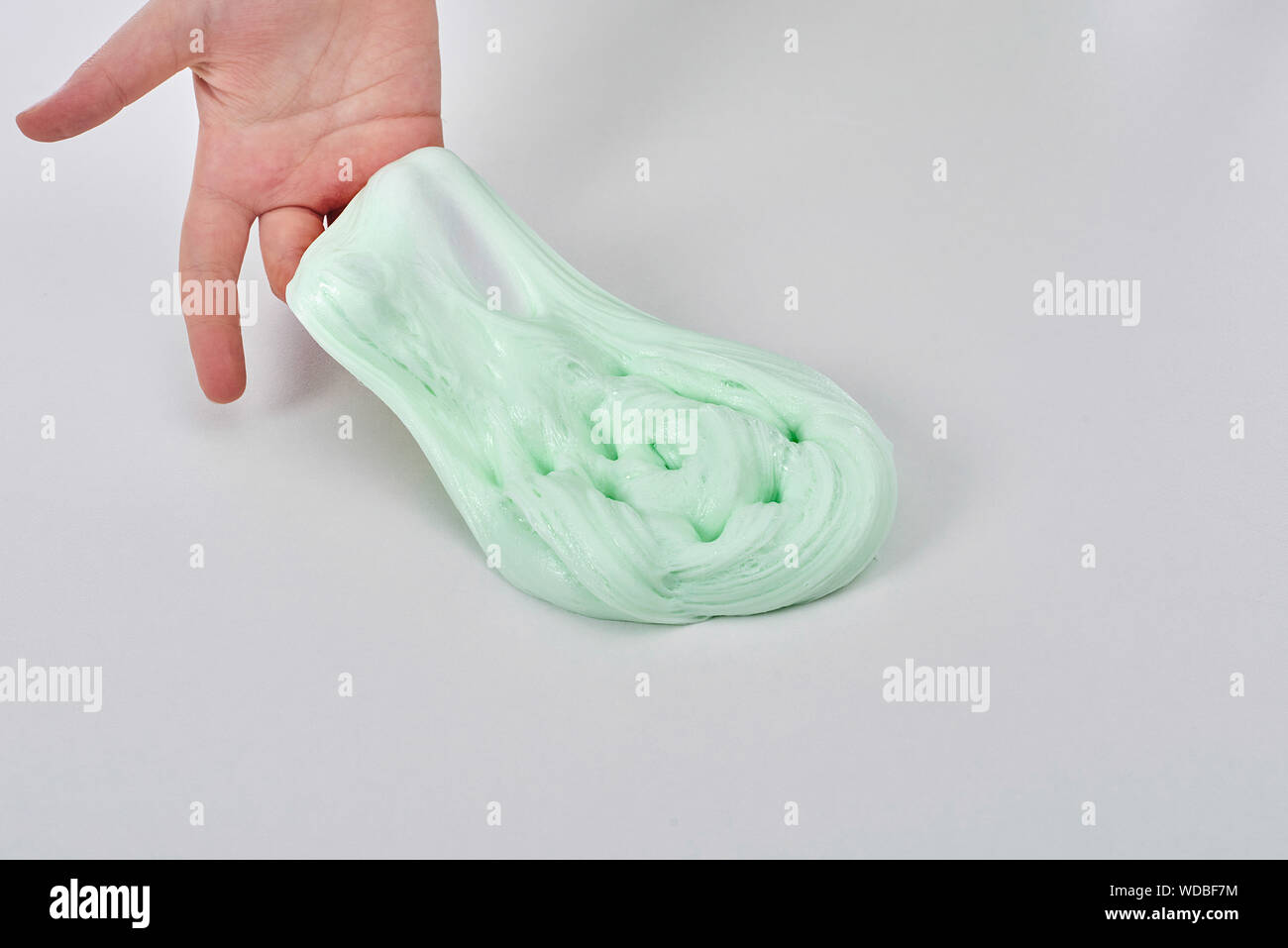 Child hand playing with toy called slime. Isolated on white background ...