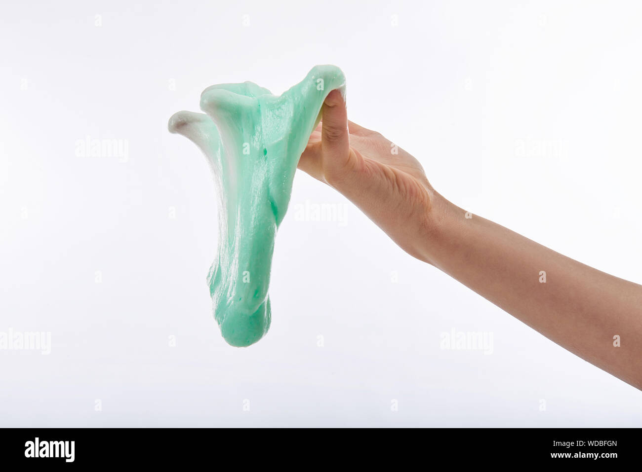 Kid hand playing with toy called slime. Isolated on white background ...