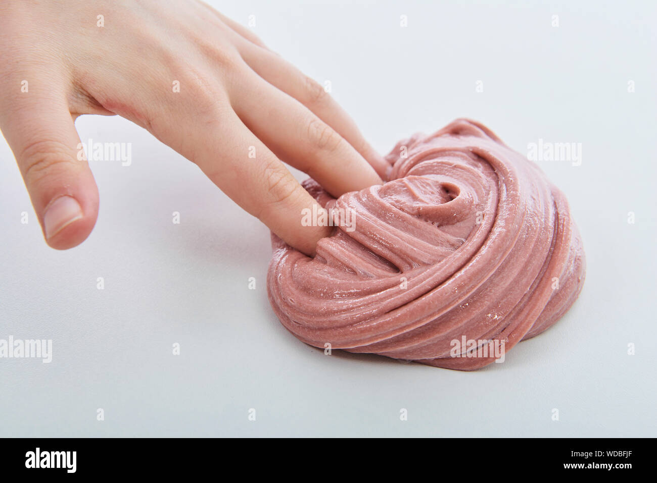 Kid hand playing with toy called slime. Isolated on white background ...