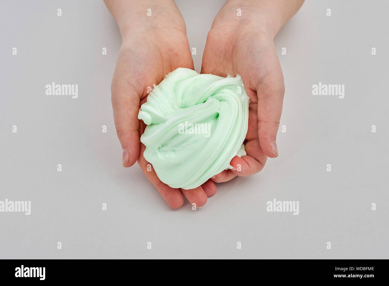 Kid hands holding piece of toy called slime Stock Photo - Alamy