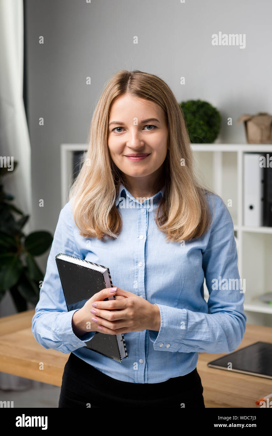 Businesswoman Holding Large File. young womanl standing in the office ...