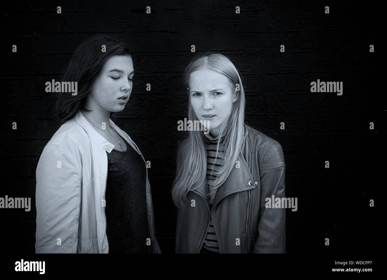 Two girls standing against wall hi-res stock photography and images - Alamy