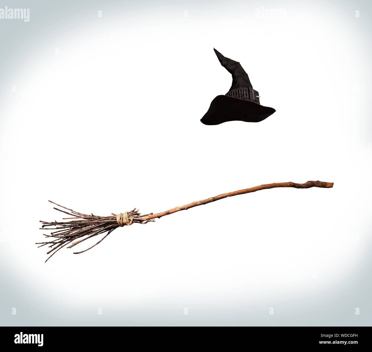 classic pointed witch hat and flying broom flying on a white background ...