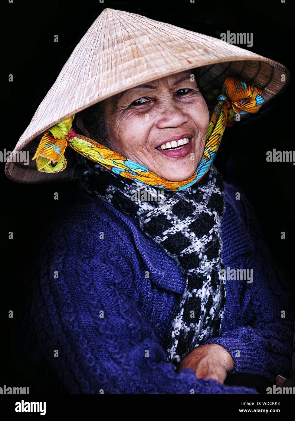 Portrait Of Smiling Senior Woman Wearing Asian Style Conical Hat