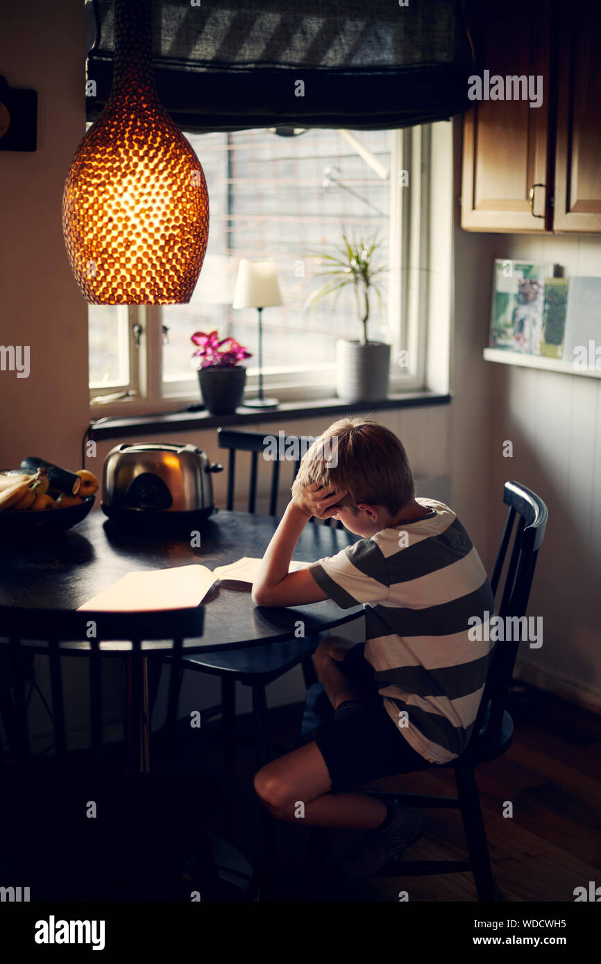 Boy sitting on the dining table hi-res stock photography and images - Alamy