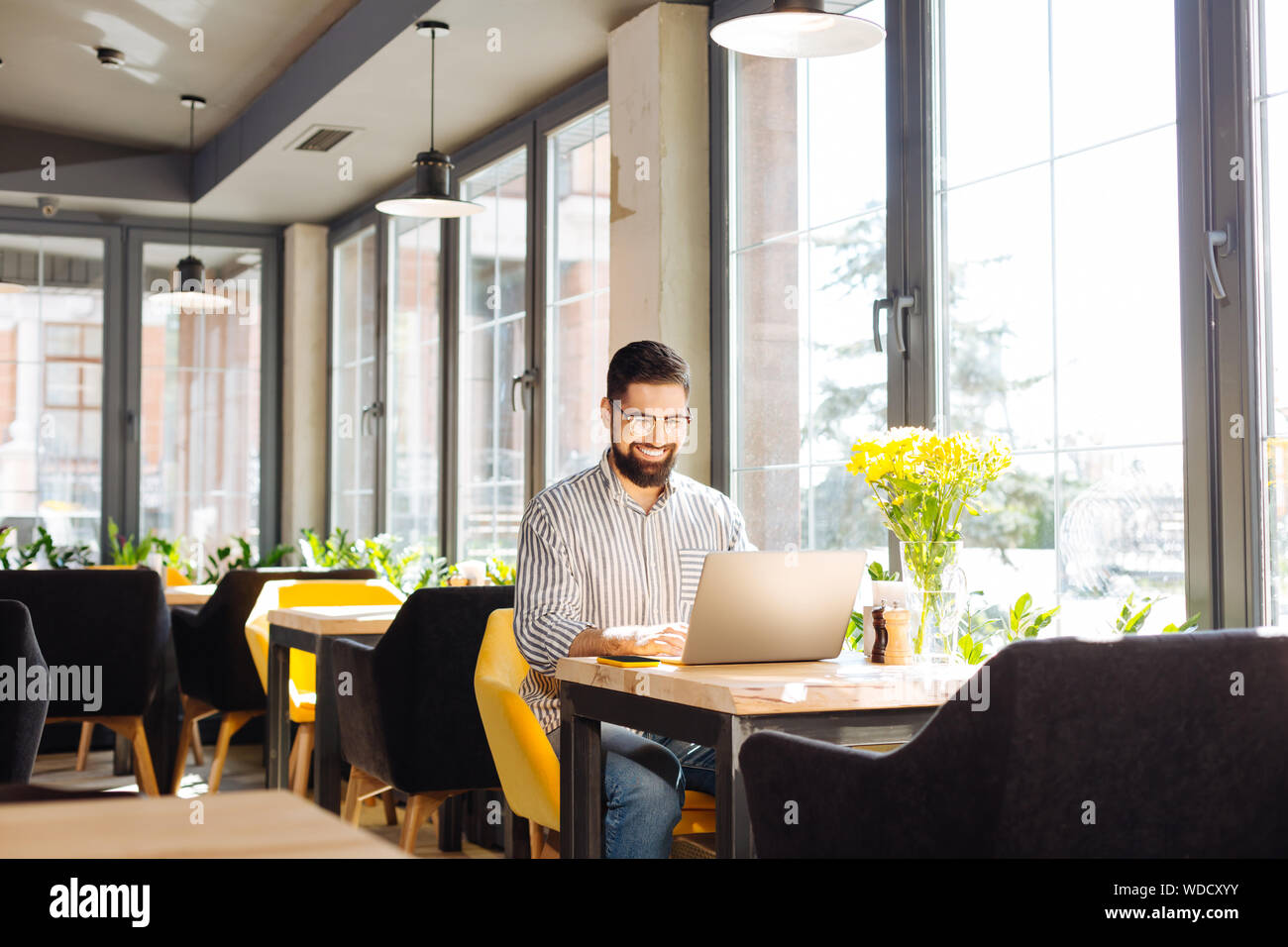 Cheerful happy young man working from the cafe Stock Photo - Alamy