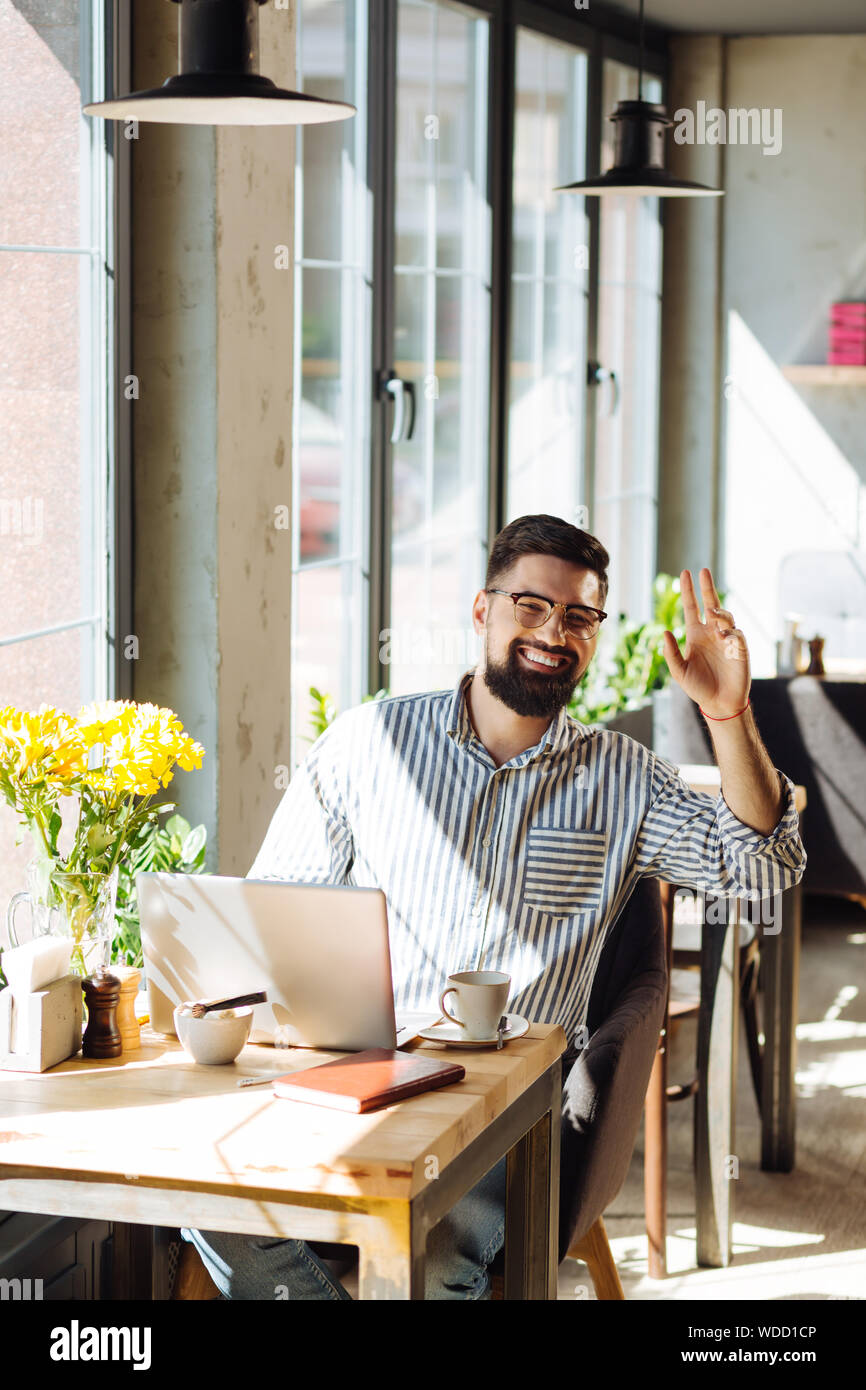 Good looking positive man raising his hand Stock Photo - Alamy