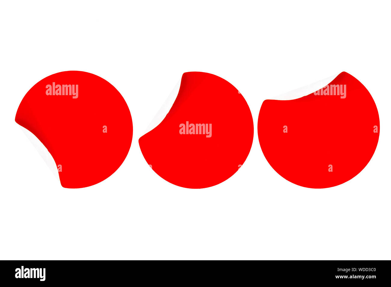 Three blank red stickers with curled side on a white background with ...
