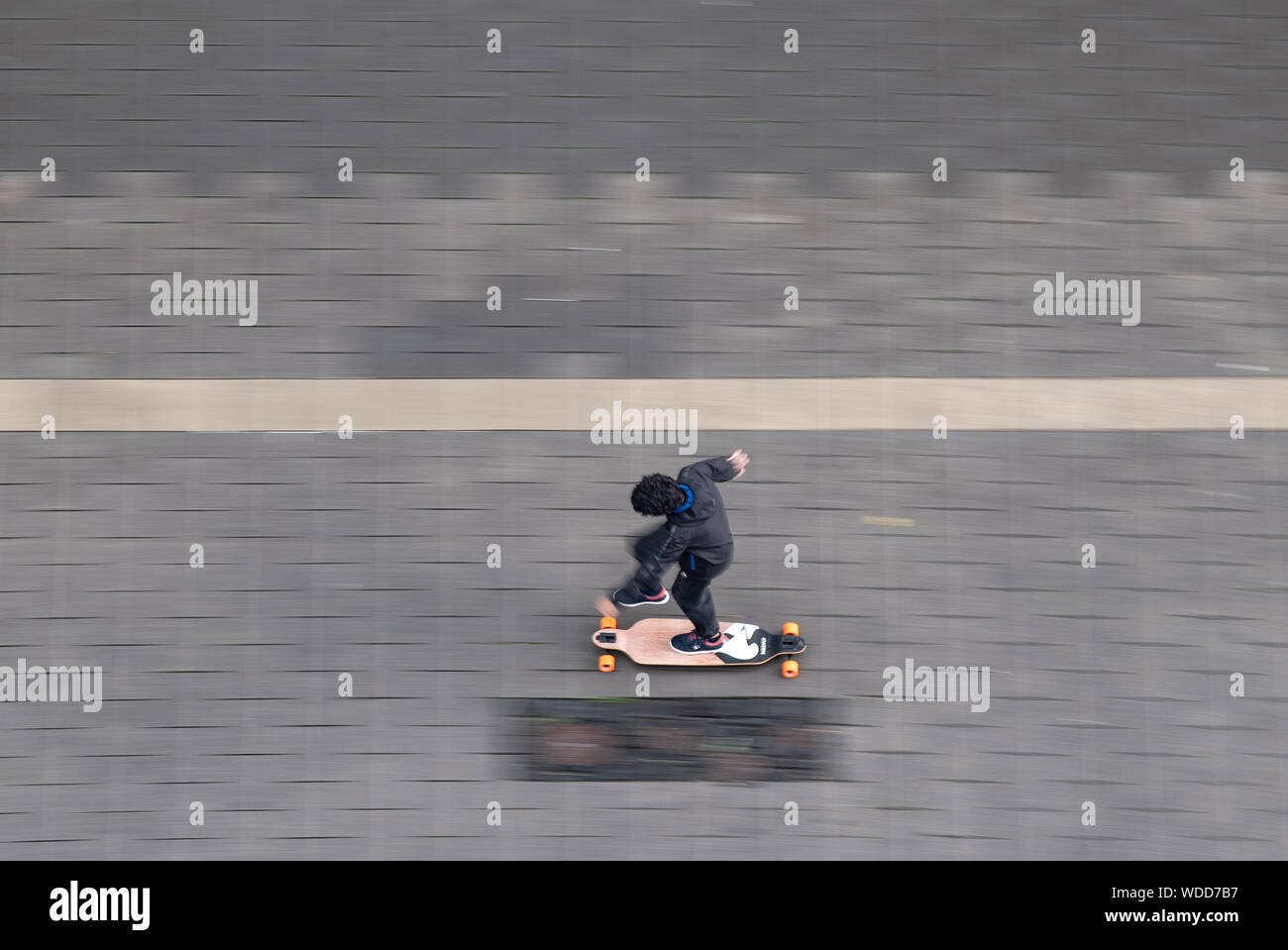 Stuttgart, Germany. 29th Aug, 2019. A longboard rider drives through ...