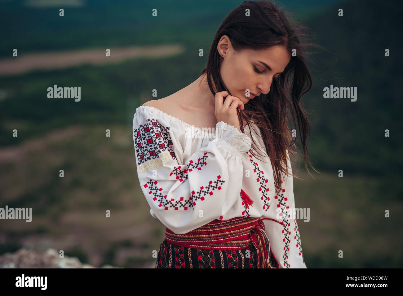 Atractive woman in traditional romanian costume on mountain green ...