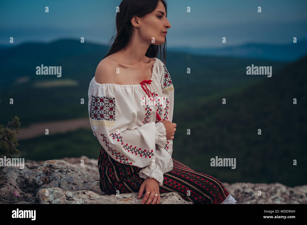 Atractive woman in traditional romanian costume on mountain green ...