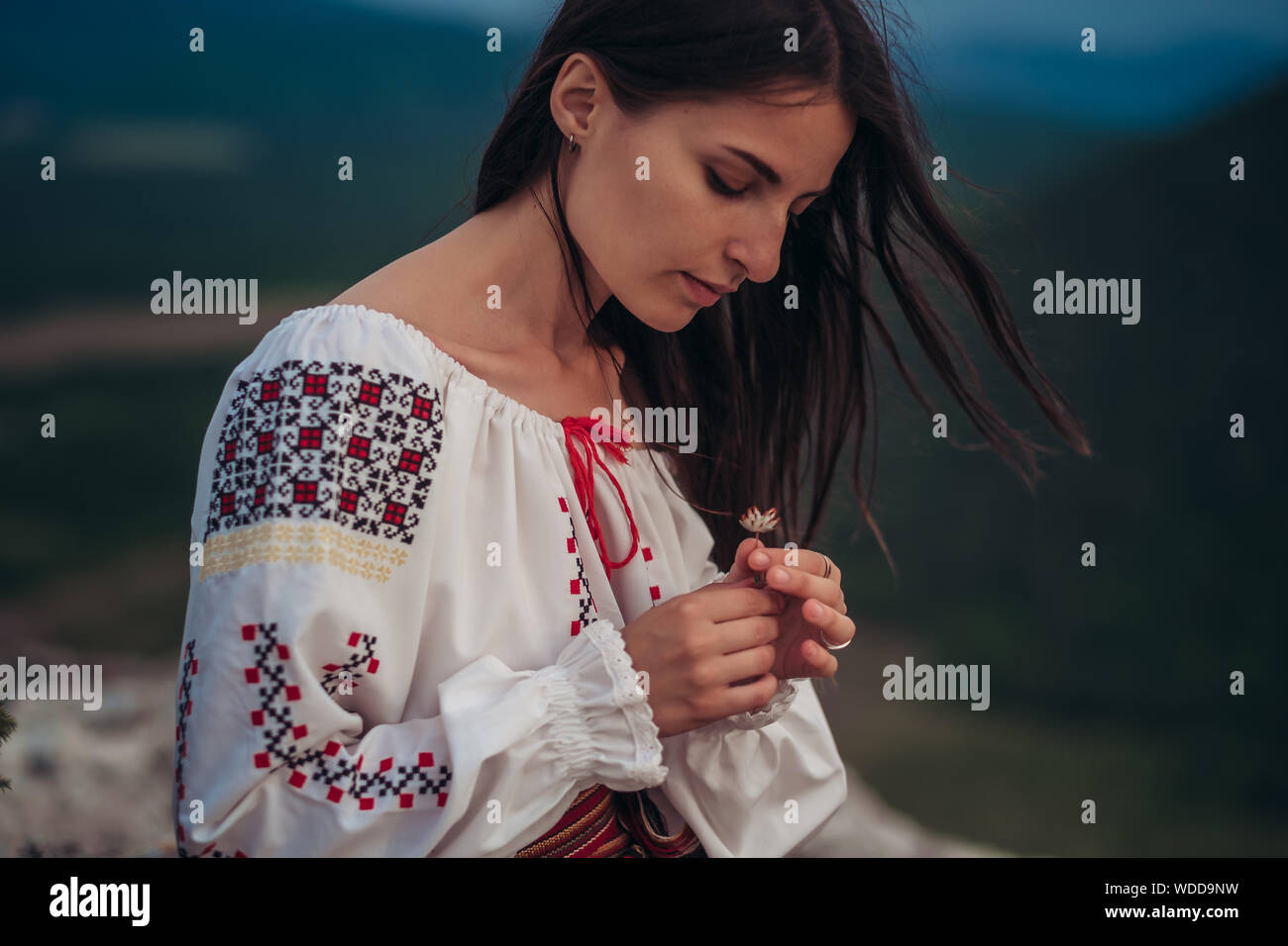 Atractive woman in traditional romanian costume on mountain green ...