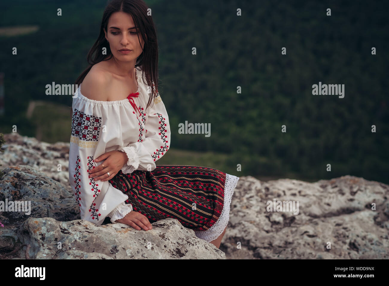 Atractive woman in traditional romanian costume on mountain green ...