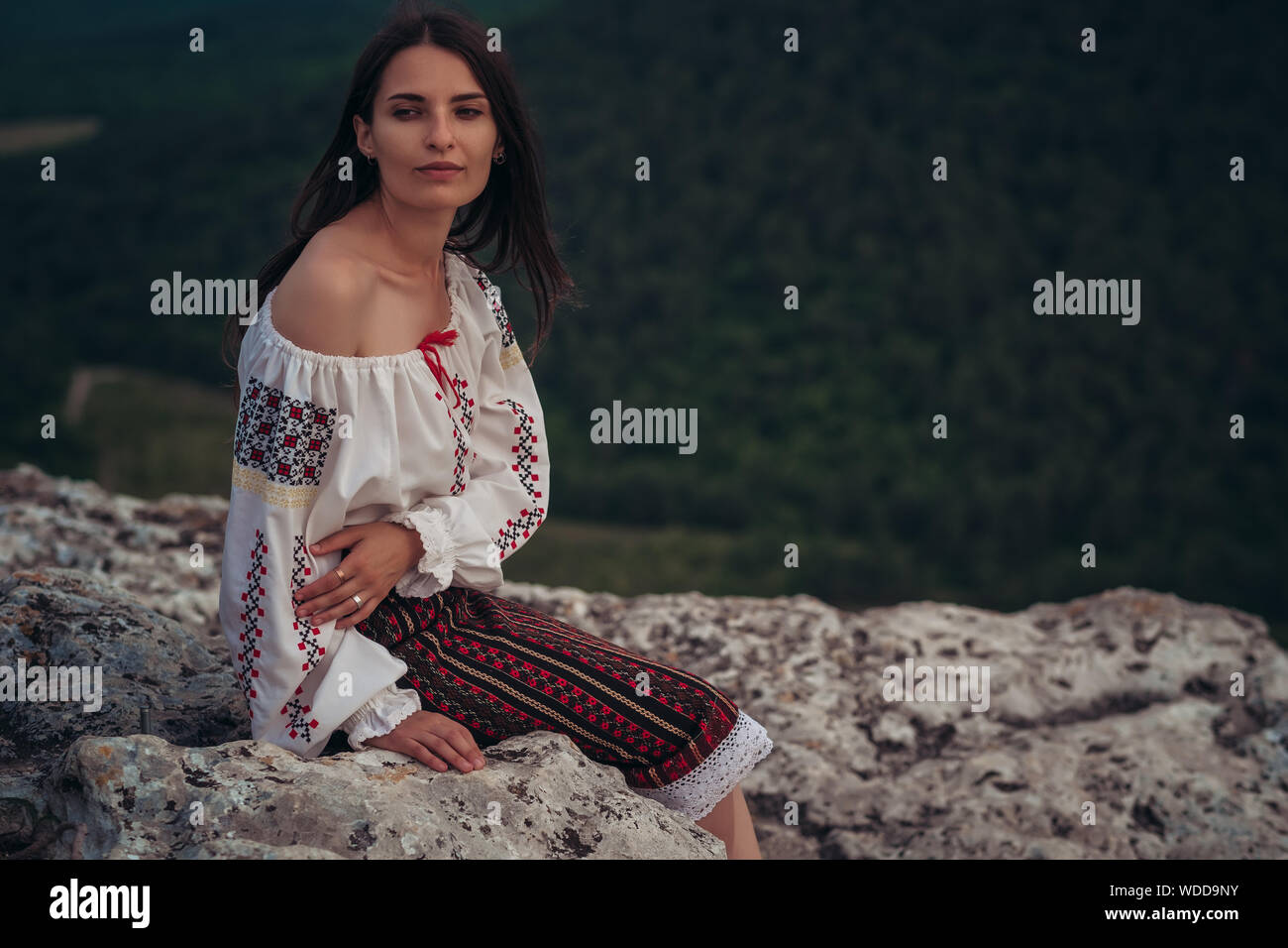 Atractive woman in traditional romanian costume on mountain green ...