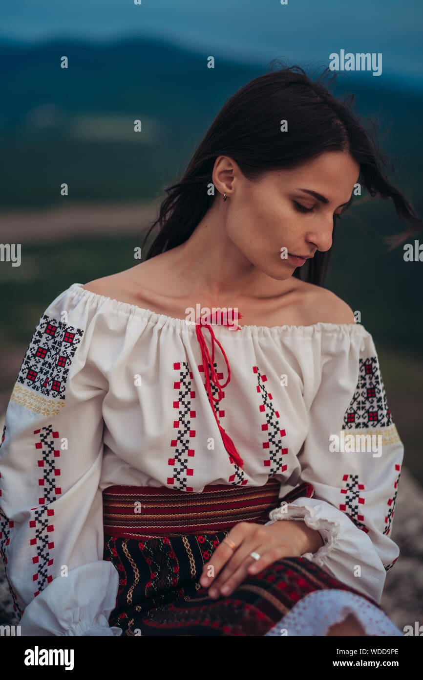 Atractive woman in traditional romanian costume on mountain green ...
