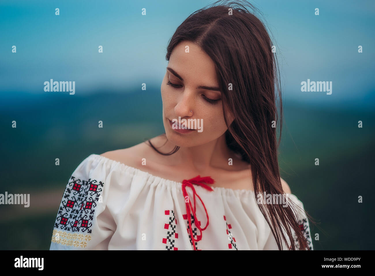 Atractive woman in traditional romanian costume on mountain green ...