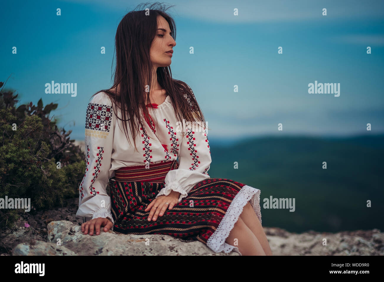 Atractive woman in traditional romanian costume on mountain green ...