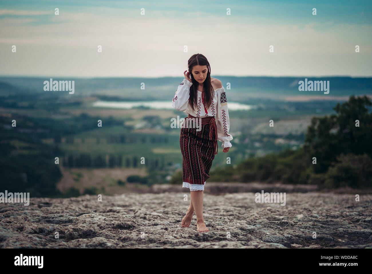 Atractive woman in traditional romanian costume on mountain green ...