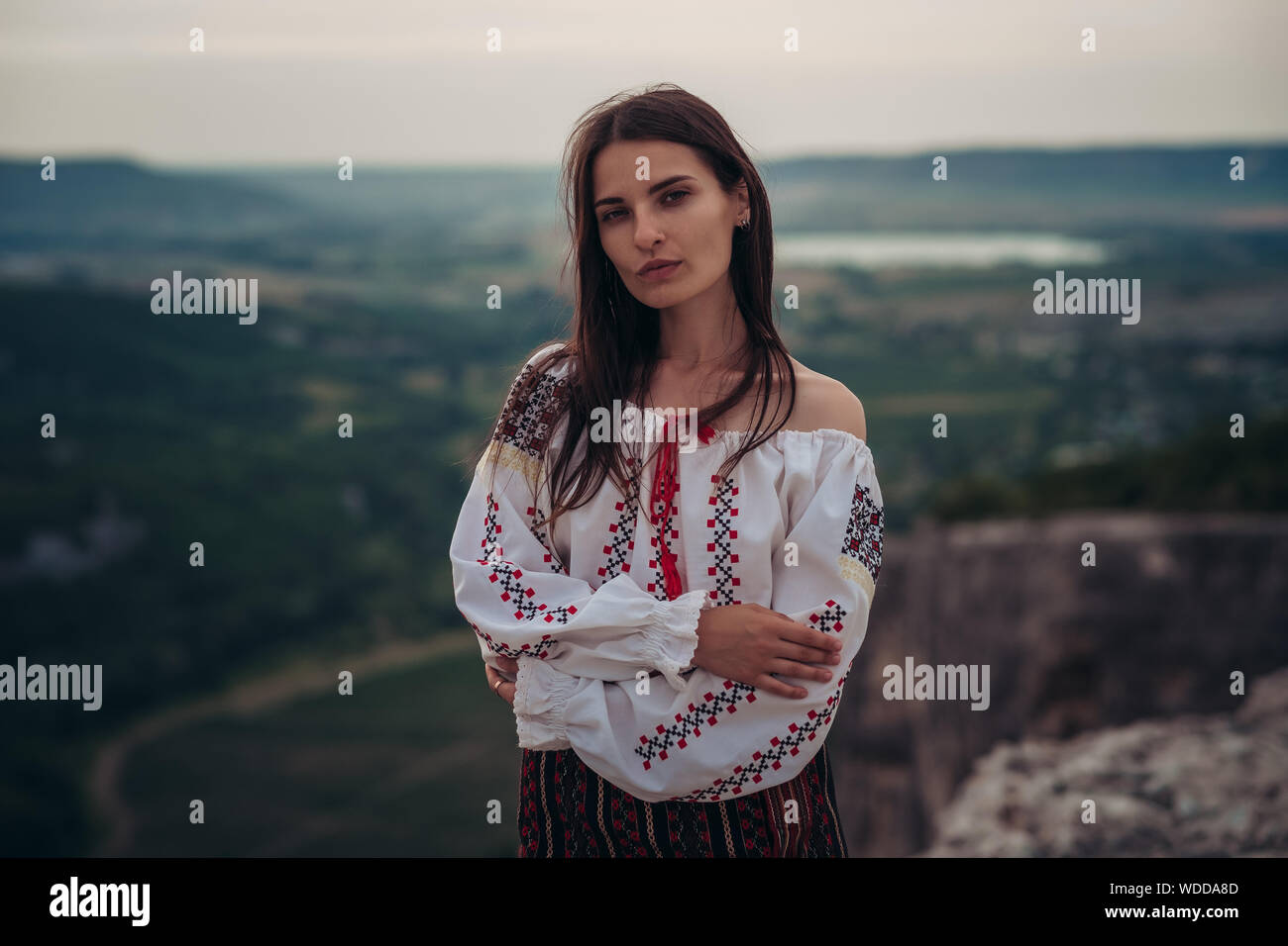 Atractive woman in traditional romanian costume on mountain green ...