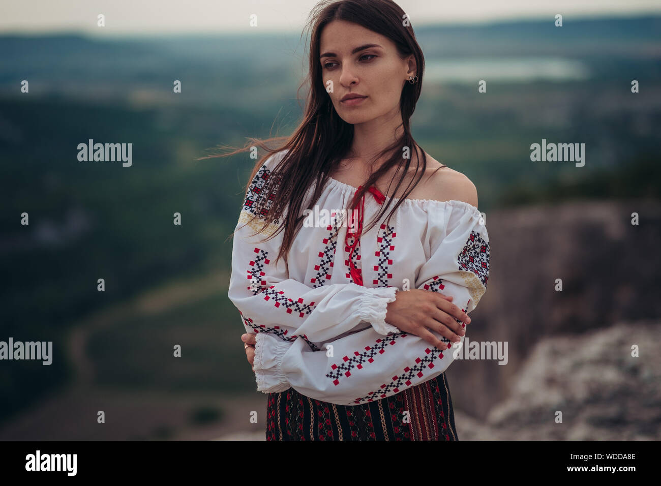 Atractive woman in traditional romanian costume on mountain green ...
