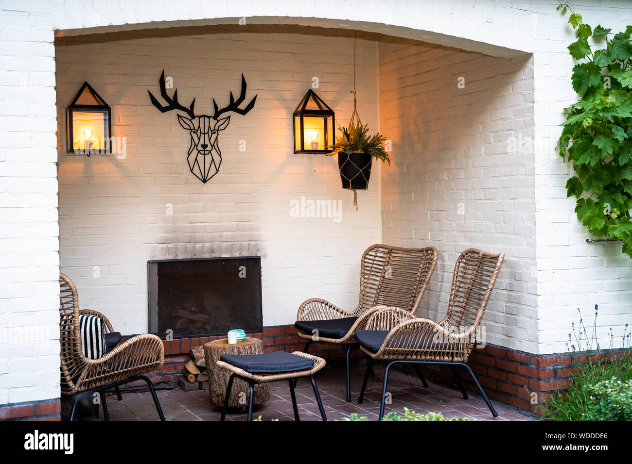 outdoor lounge set in a green garden in the alcove of a white painted ...