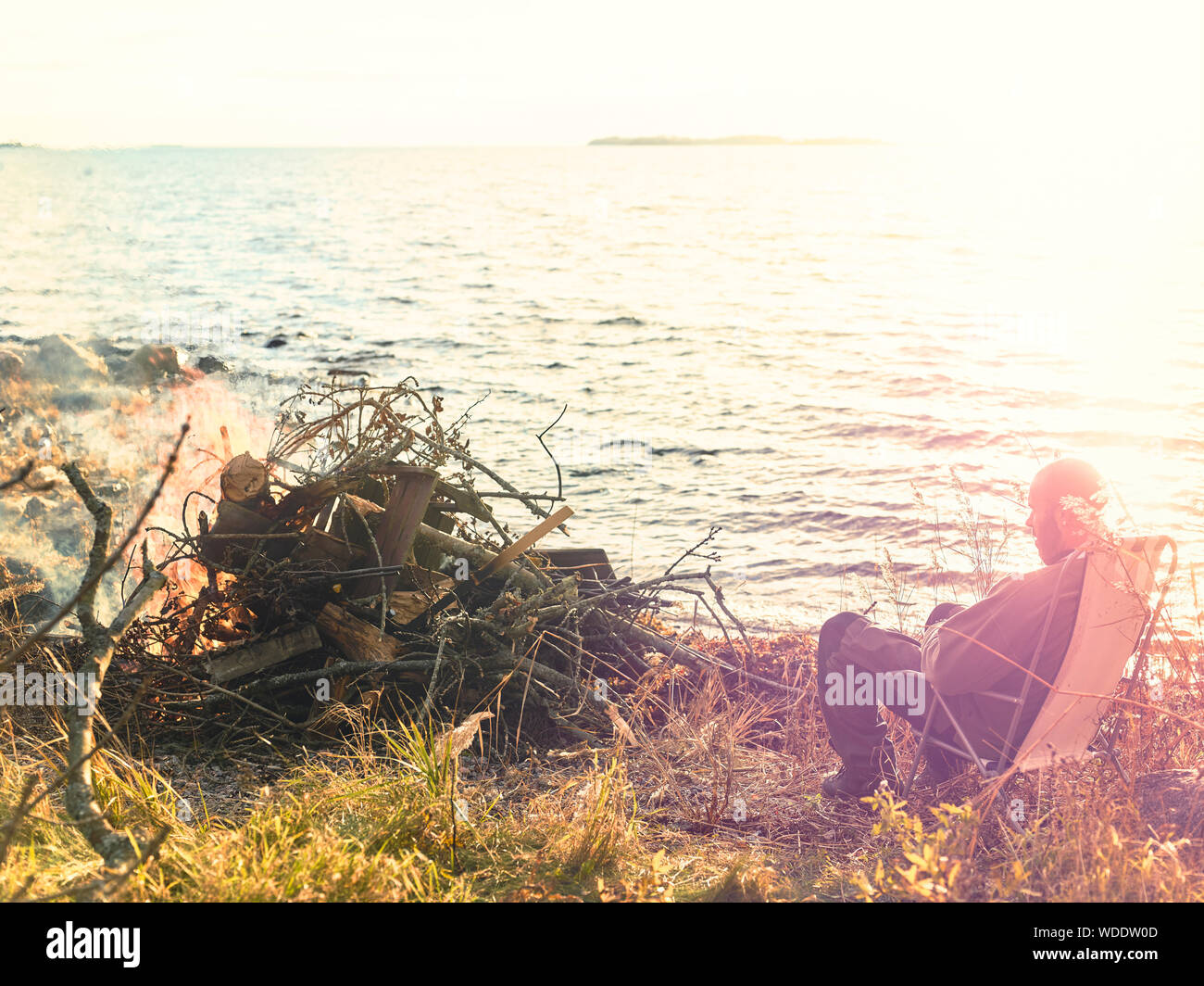 Mid adult man sitting bonfire hi-res stock photography and images - Alamy