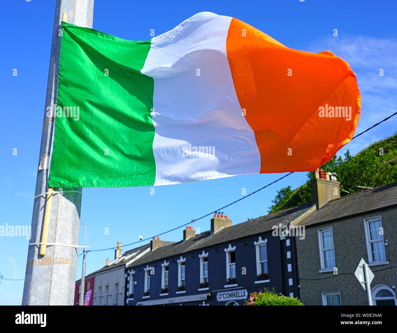 HOWTH, IRELAND- 27 JUL 2019- View of an Irish flag floating in the wind ...